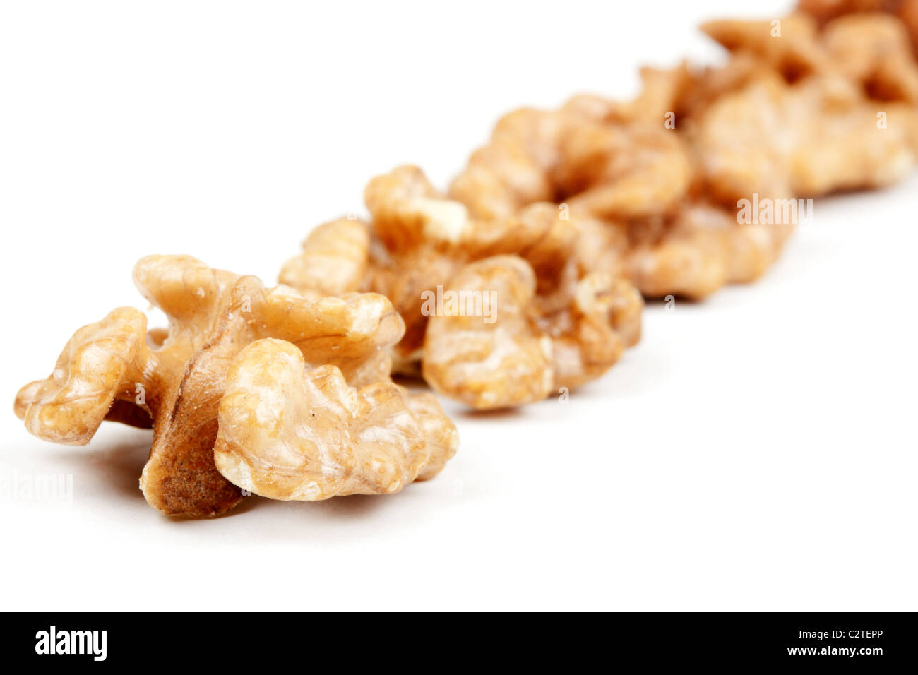 halves peeled walnuts arranged in a line on a white background Stock ...