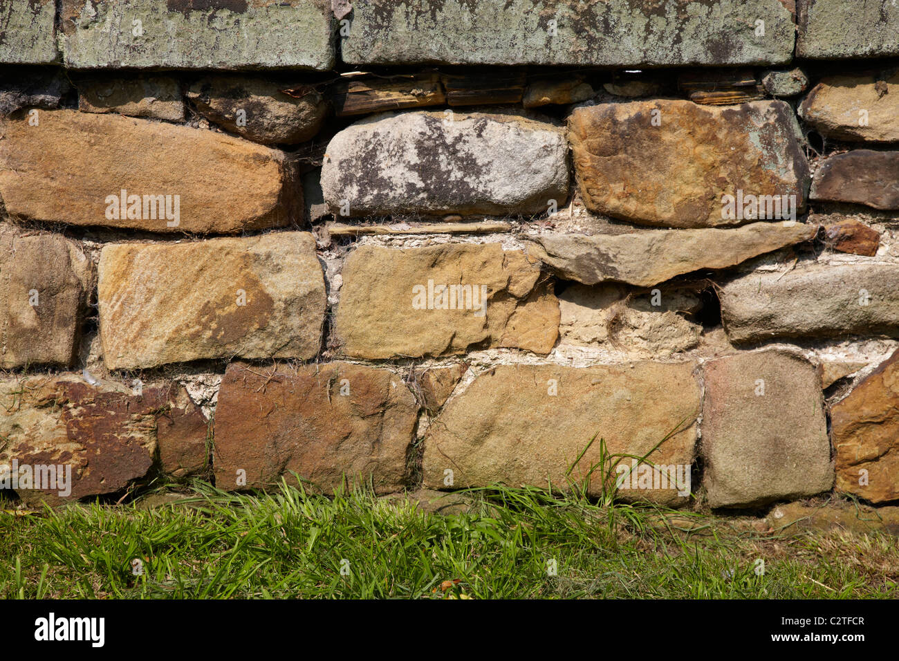 Side on shot of traditional stone wall with grass verge. Landscape ...