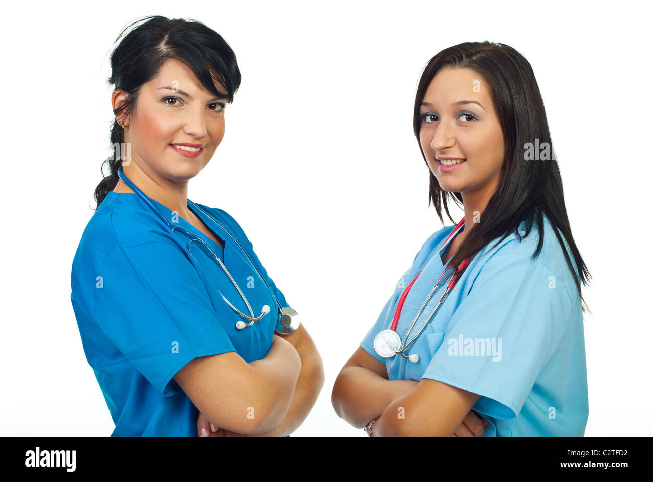 Two physicians women smiling and standing with arms folded isolated on ...