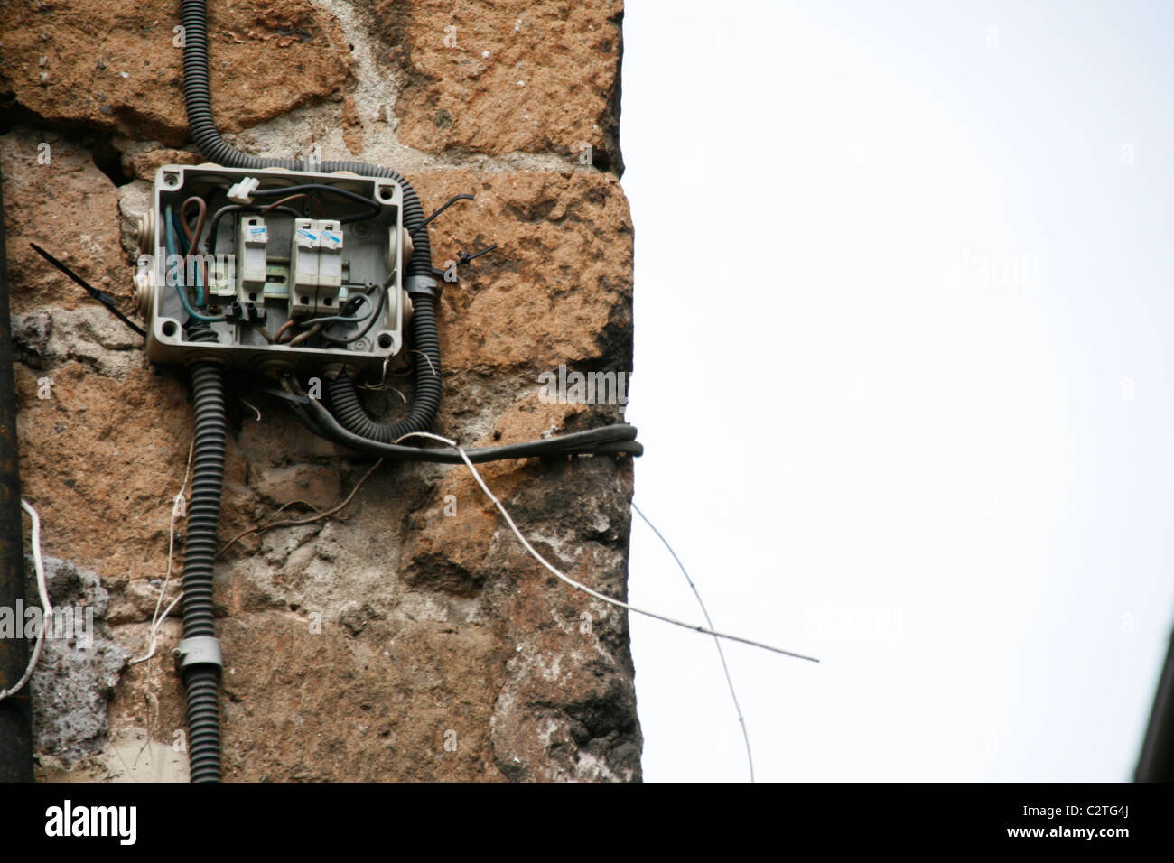 electricity power wiring circuit cables tubes on side of property wall ...