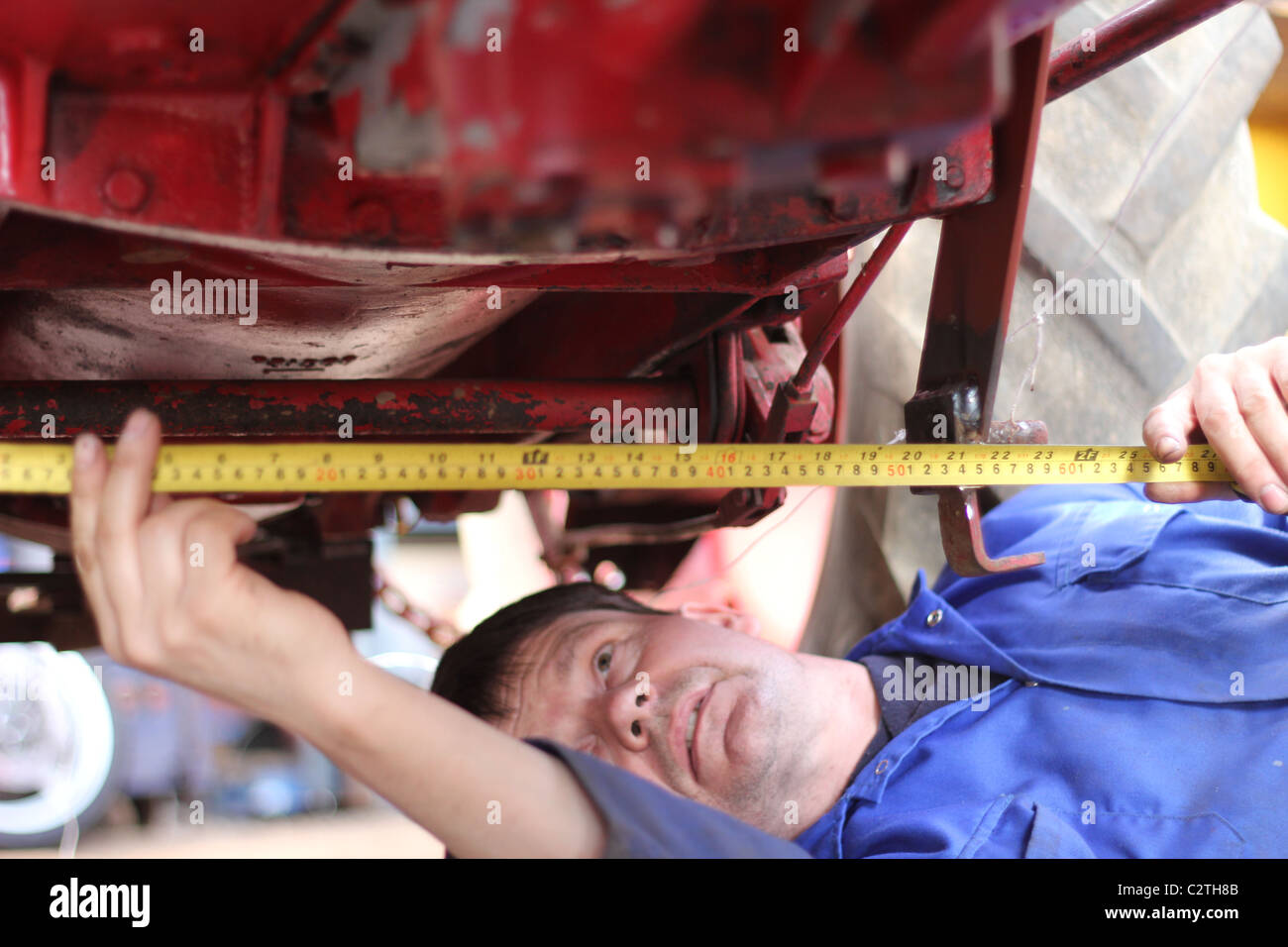 Engineer under Tractor Stock Photo - Alamy
