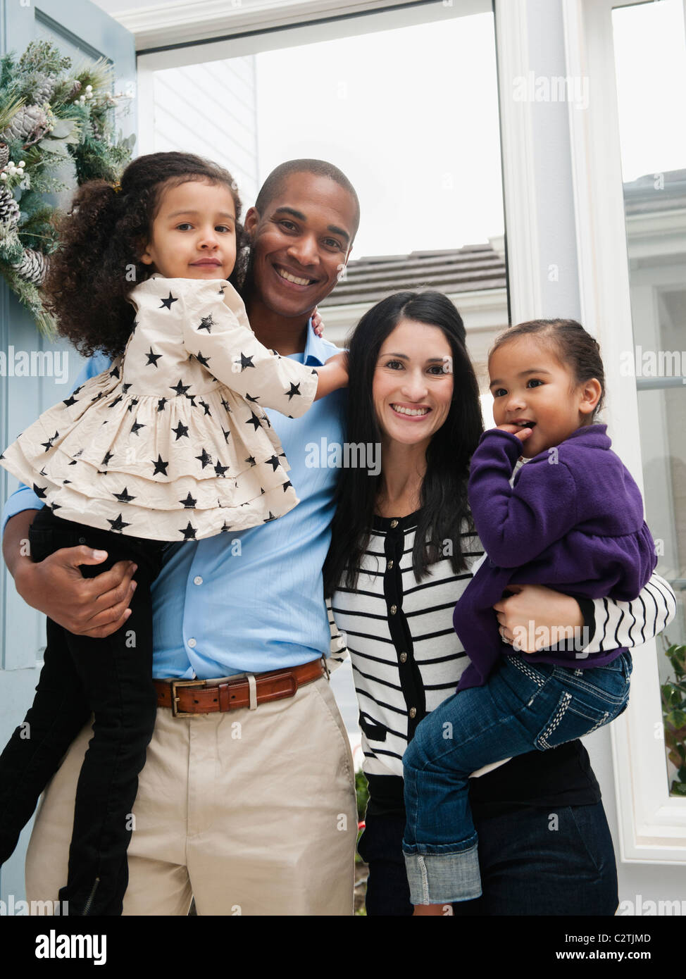 Proud parents holding daughters Stock Photo - Alamy