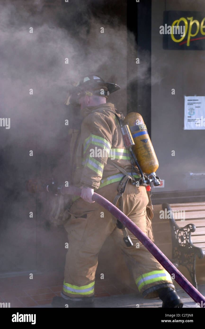 American Firefighter enters a smoke logged building Stock Photo - Alamy