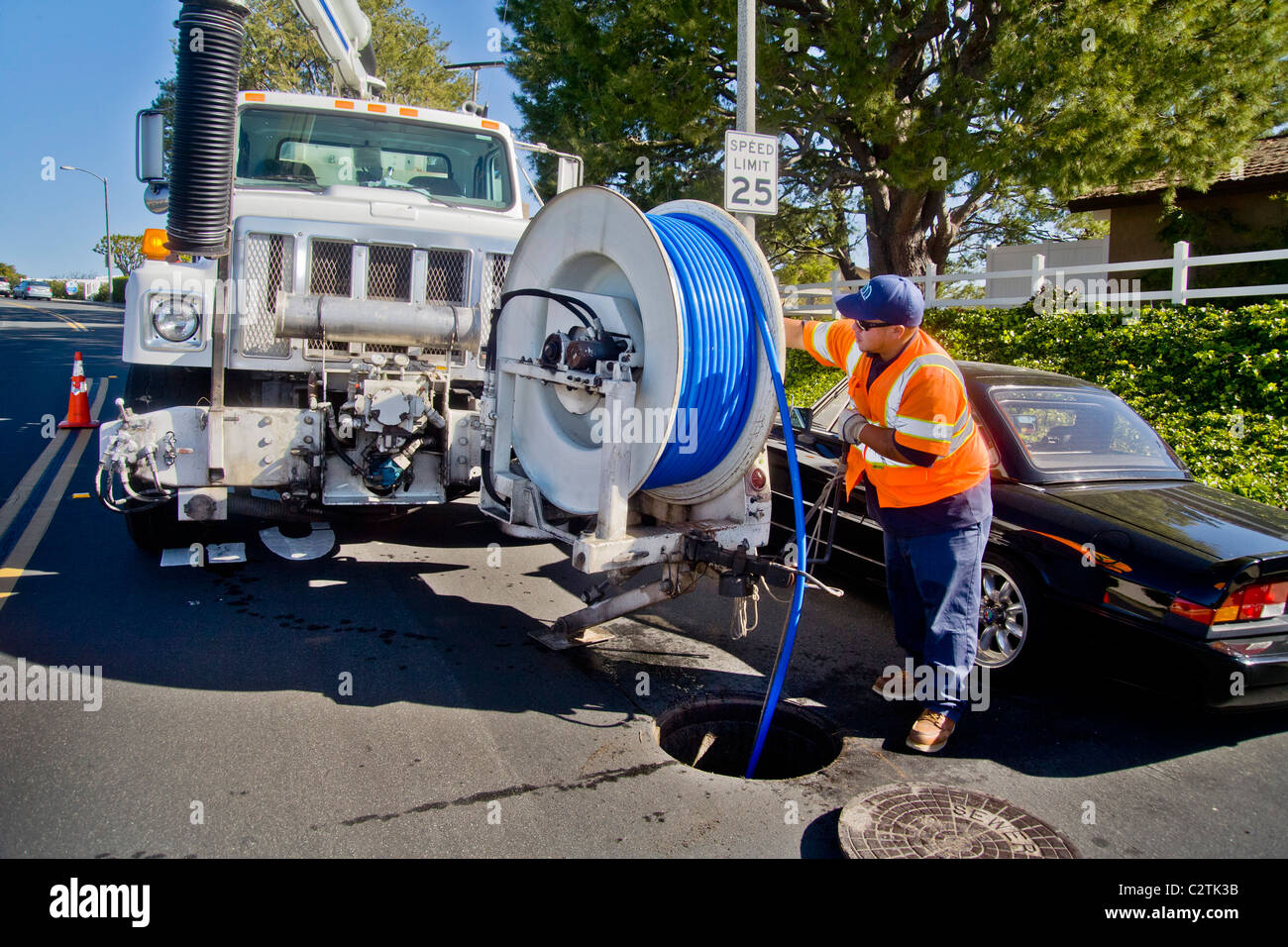 Using a truck mounted suction system, a technician cleans a clogged ...