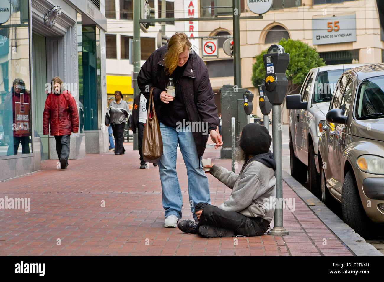 A charitable woman gives money to a homeless panhandler just off Market ...