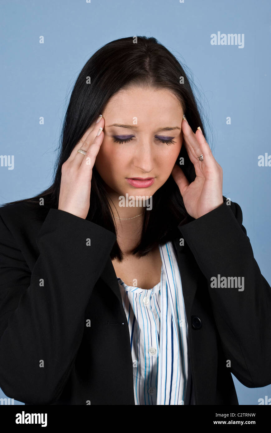 Young business woman having problems or a headache and holding hands to ...