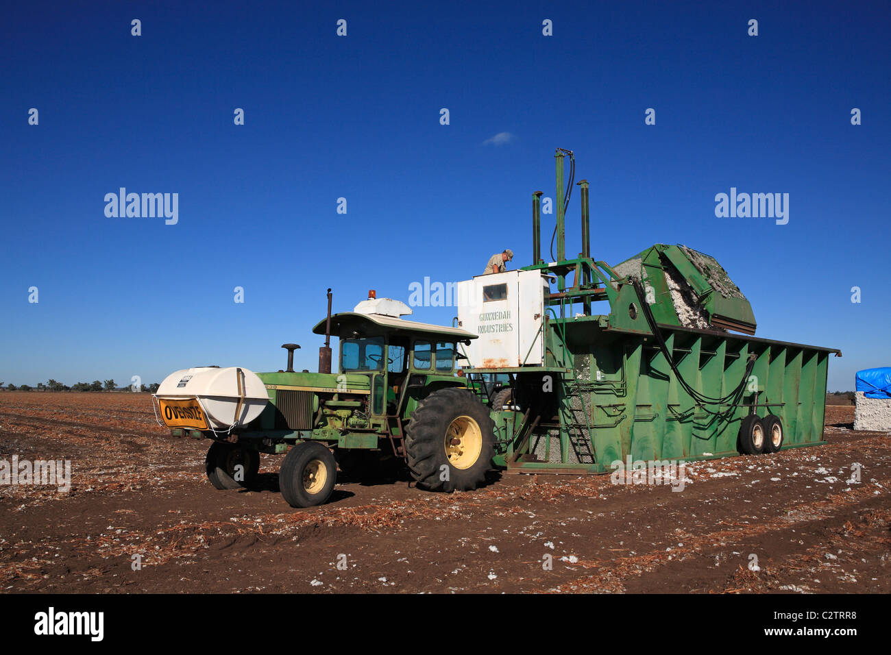 John Deere tractor attached to a cotton module builder, or compacting ...