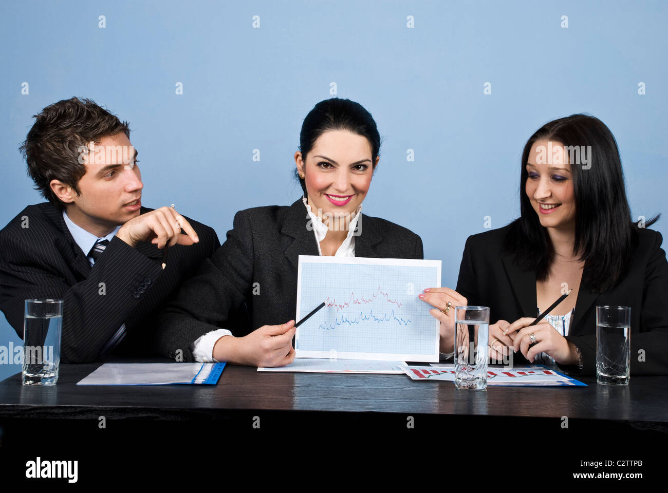 Business people sitting in a line at table and having a meeting ,they ...