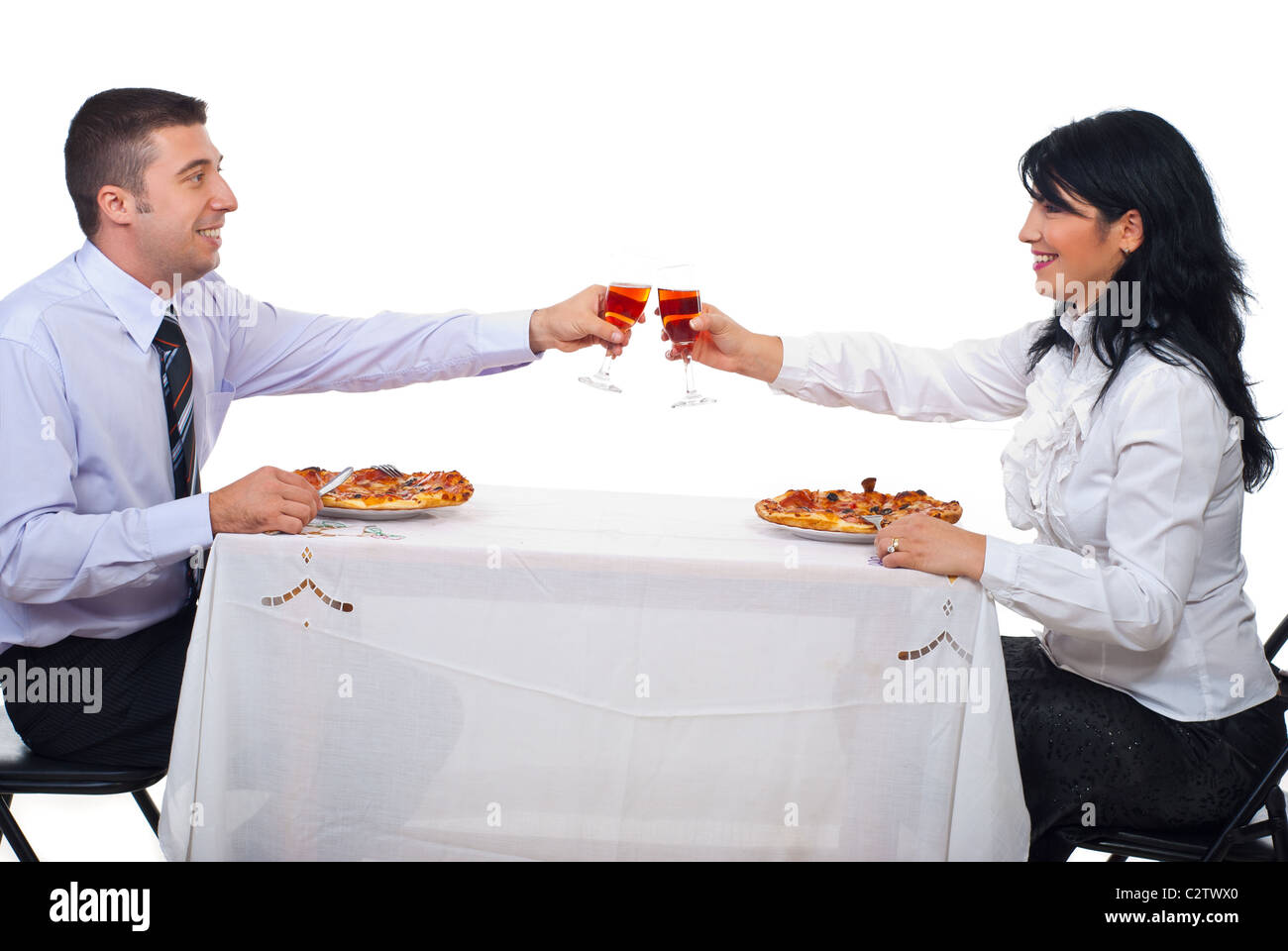 Two business people toasting with wine and eating pizza at table Stock ...
