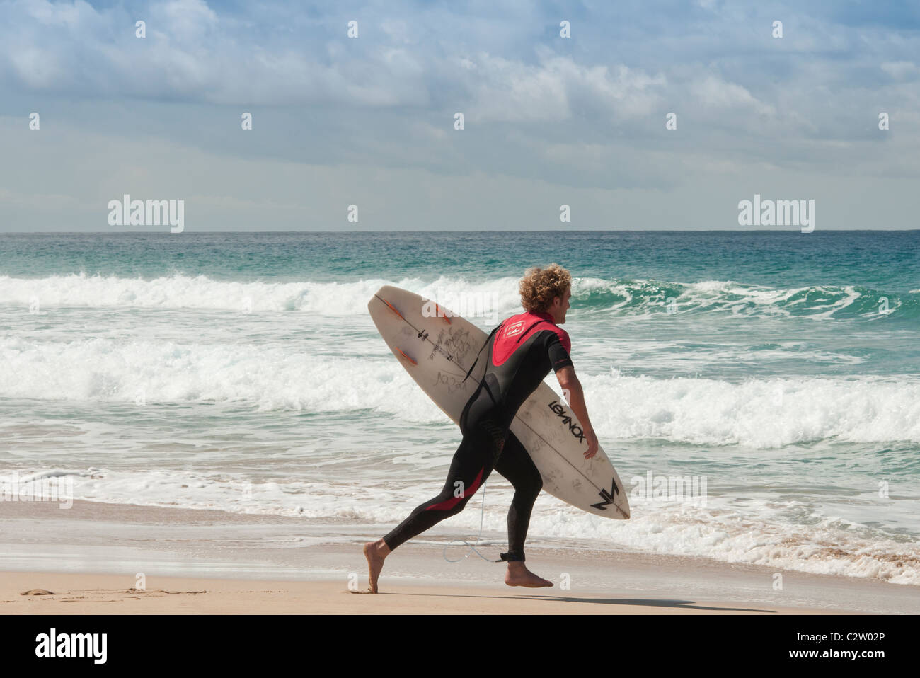 surfer running into the surf, El Cotillo, Fuerteventura, Canary Islands ...