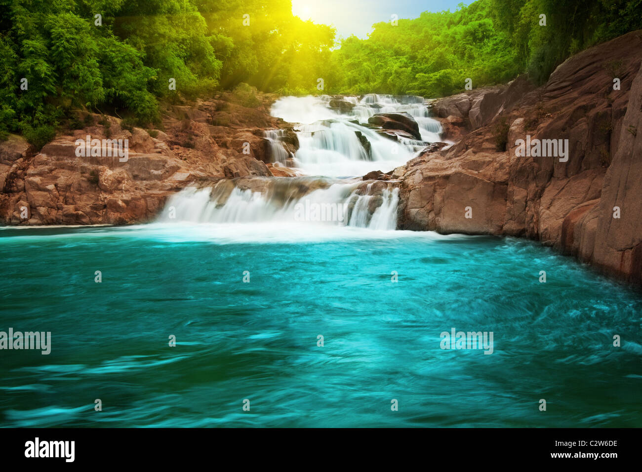 Waterfall pool in rain forest and sunlight Stock Photo - Alamy