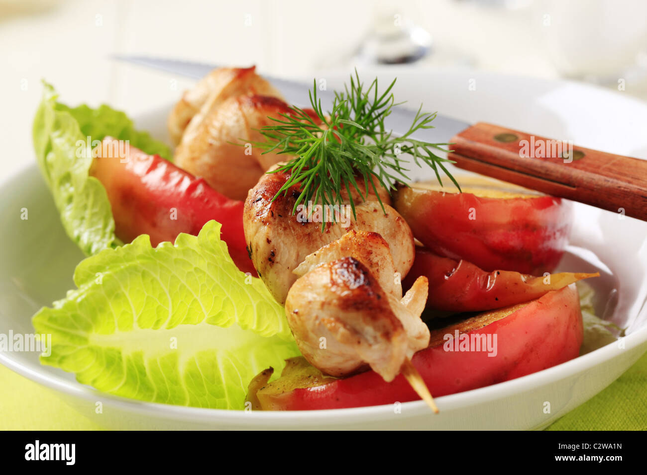 Roasted chicken skewer and slices of baked apple Stock Photo - Alamy