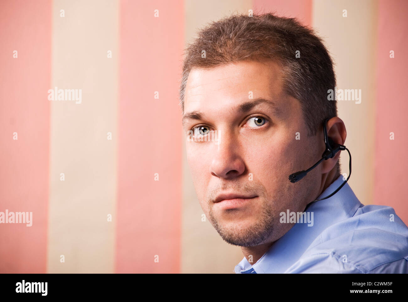 Portrait of mid adult man operator worker with headset looking at you ...