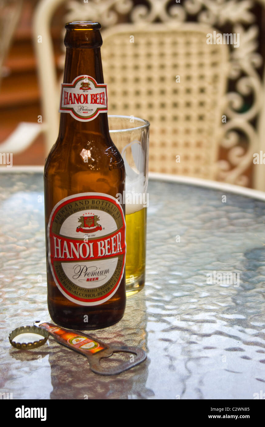 Vertical close up of a half empty glass and bottle of Hanoi Beer on a ...