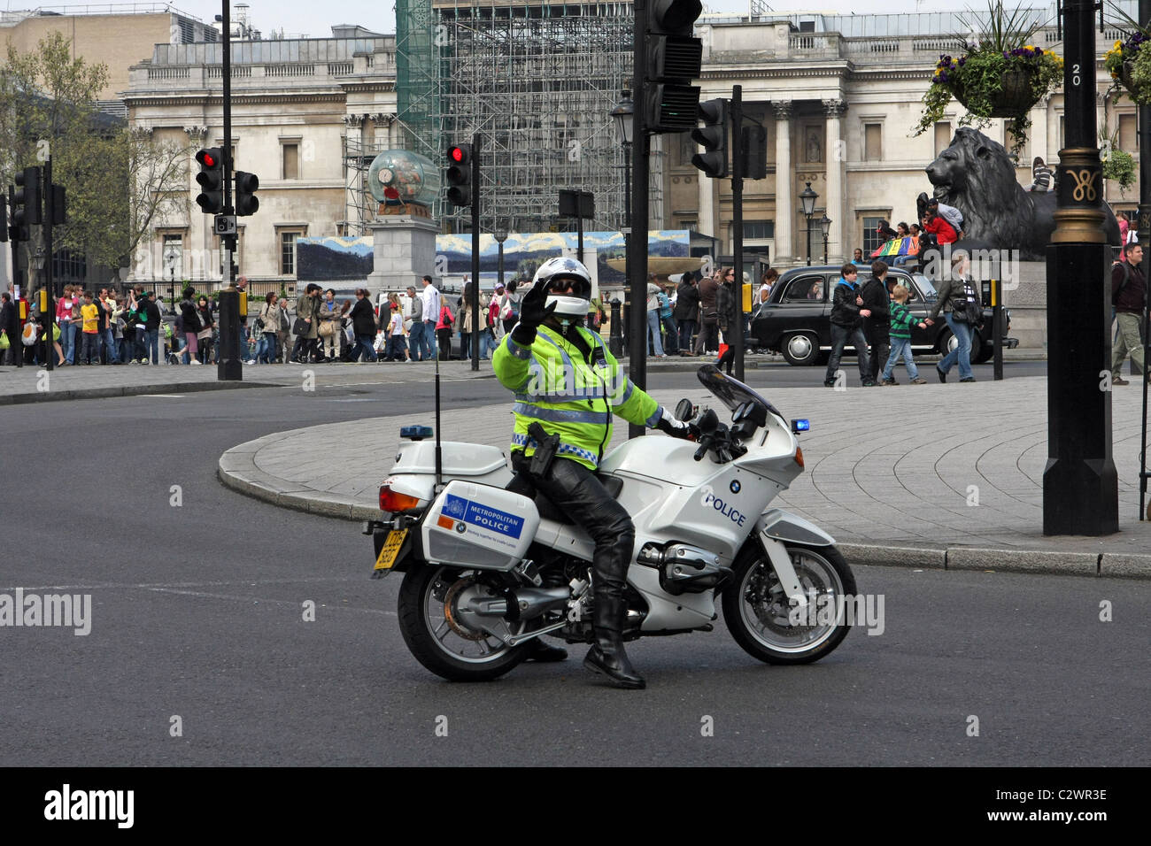 A motorcycle policeman stopping traffic at Trafalgar Square in London ...