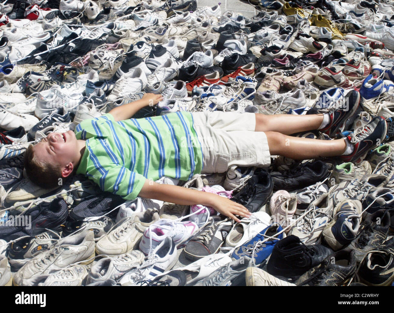 Peter Wajda lays atop a mound of 10, 512 shoes on display in the ...