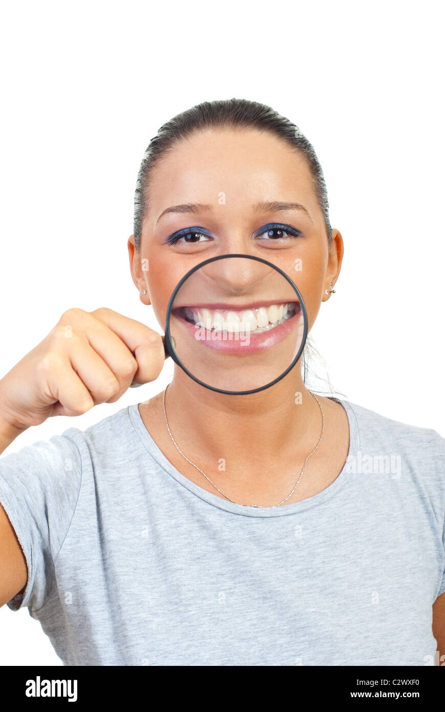 Funny young woman using magnifying glass to enlarge her smile isolated ...