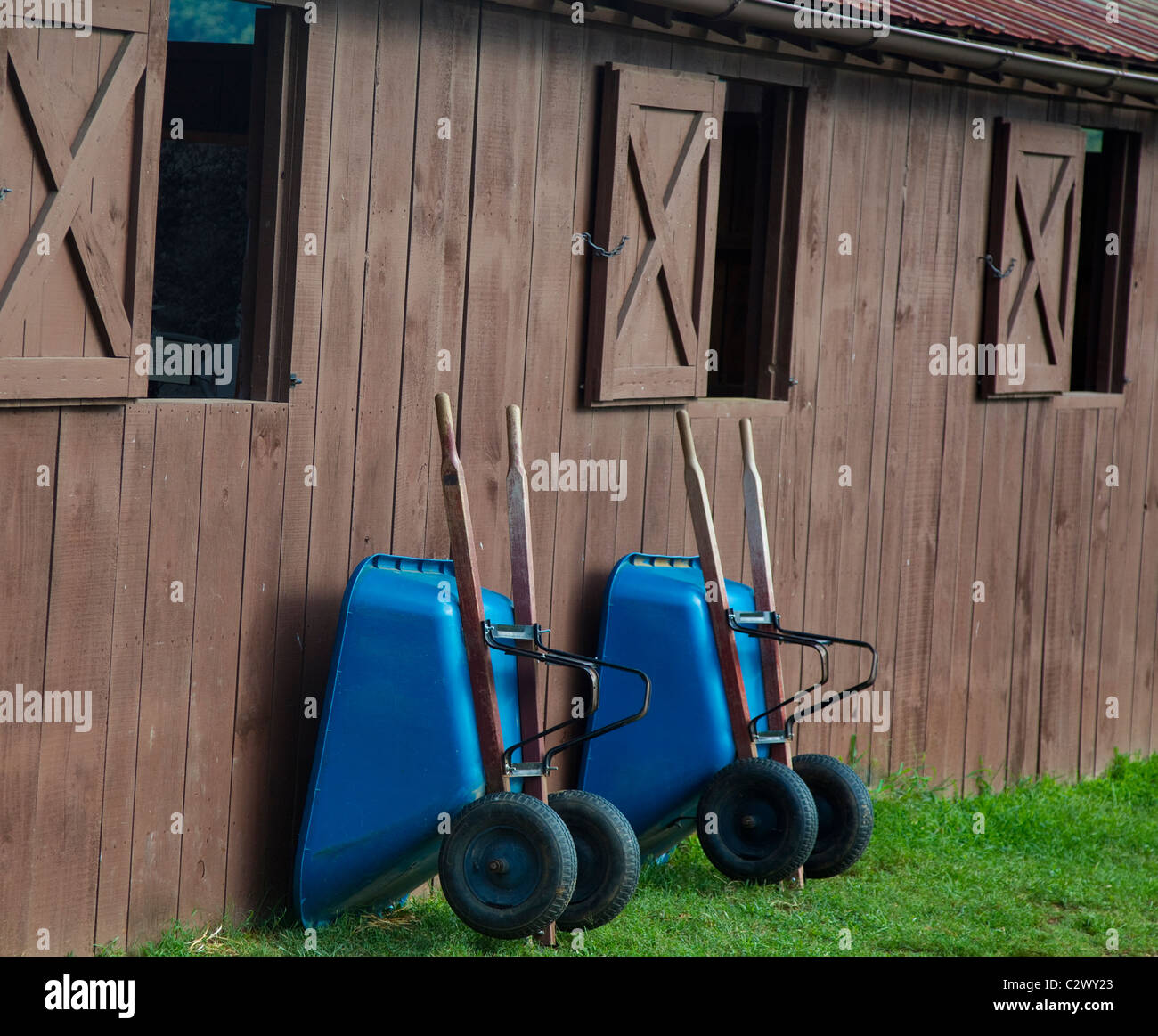 Wheelbarrows leaning against a barn Stock Photo - Alamy