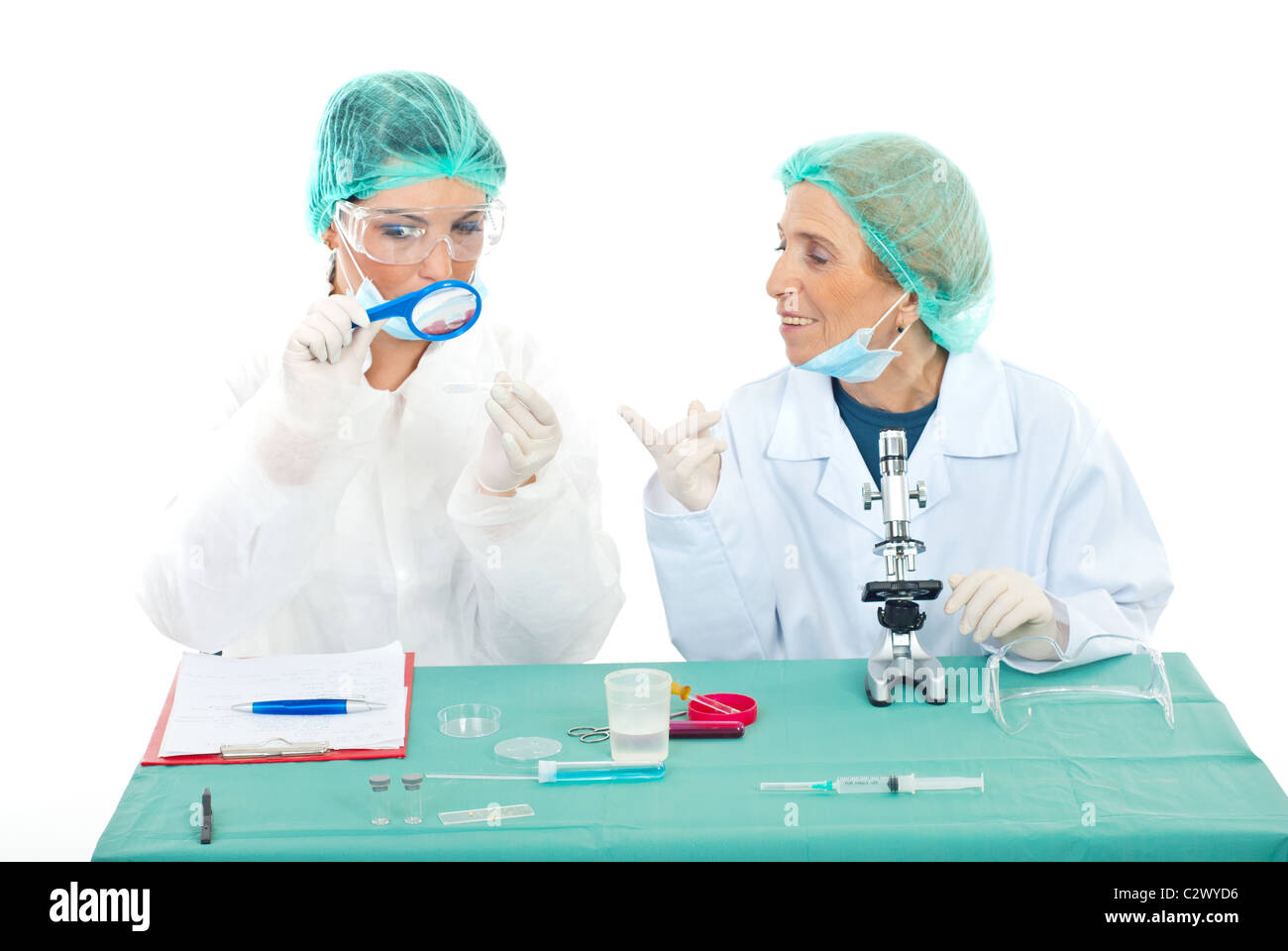Senior woman teaching a student to use magnifying glass in laboratory ...