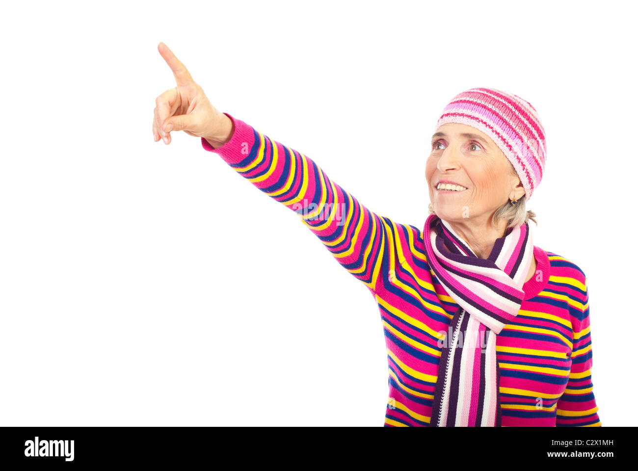 Smiling senior woman in woolen cap pointing away isolated on white ...