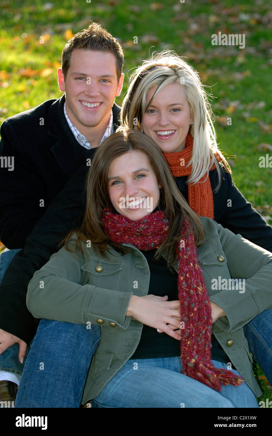 Three Friends Sitting On A Hillside Outside On A Sunny The Fall Autumn ...