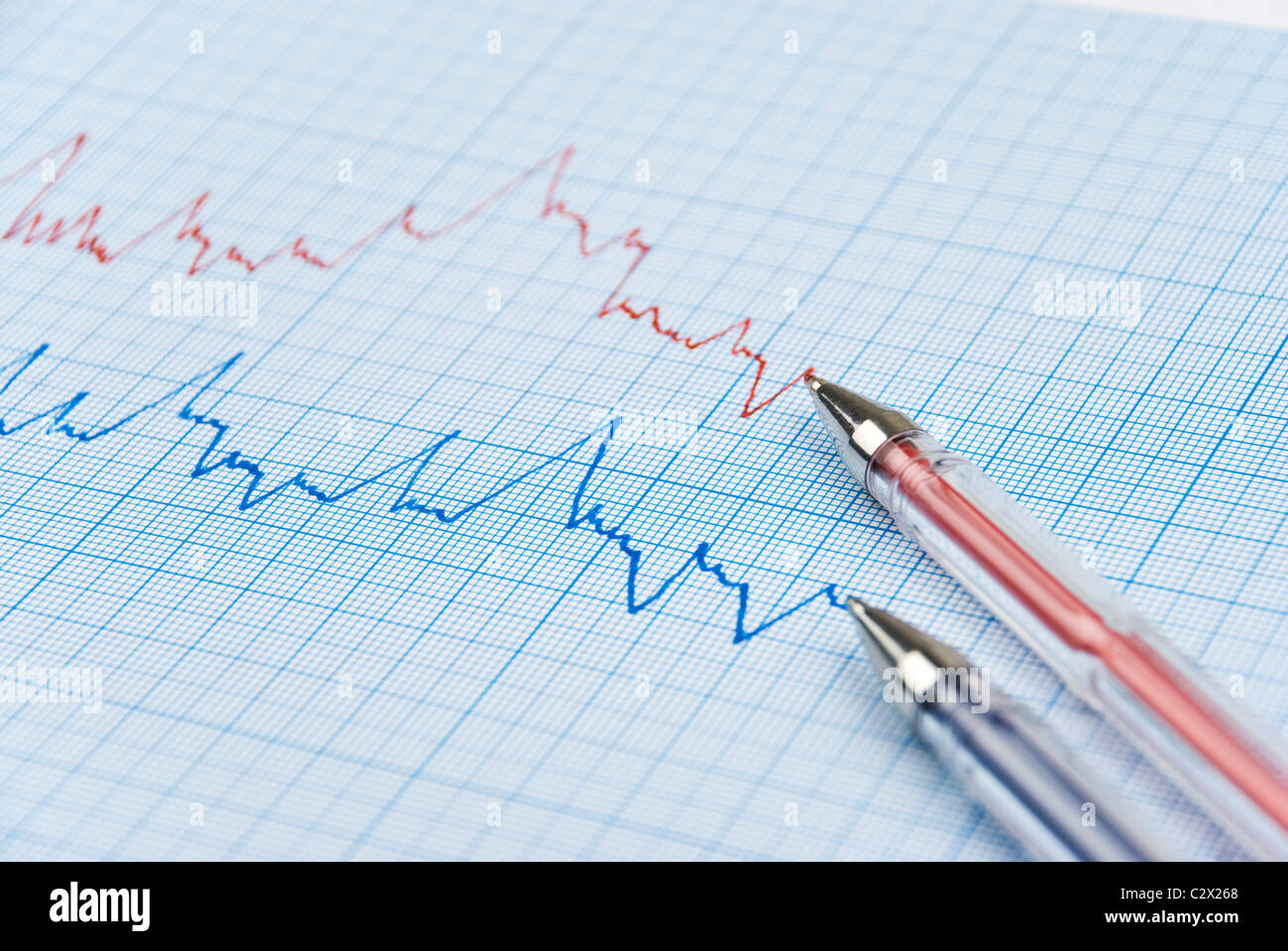 Financial chart shows a graph in two colors red and blue with two pens ...