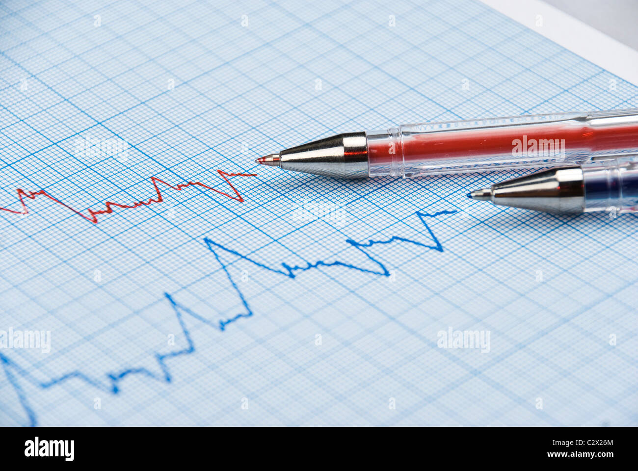 Financial chart shows a graph in two colors red and blue with two pens ...