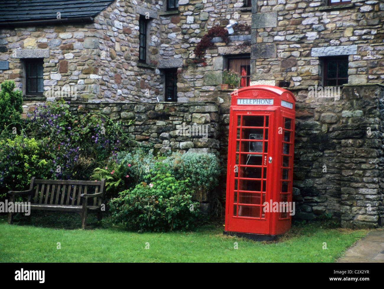 Typical red english phone booth in a small village Stock Photo - Alamy