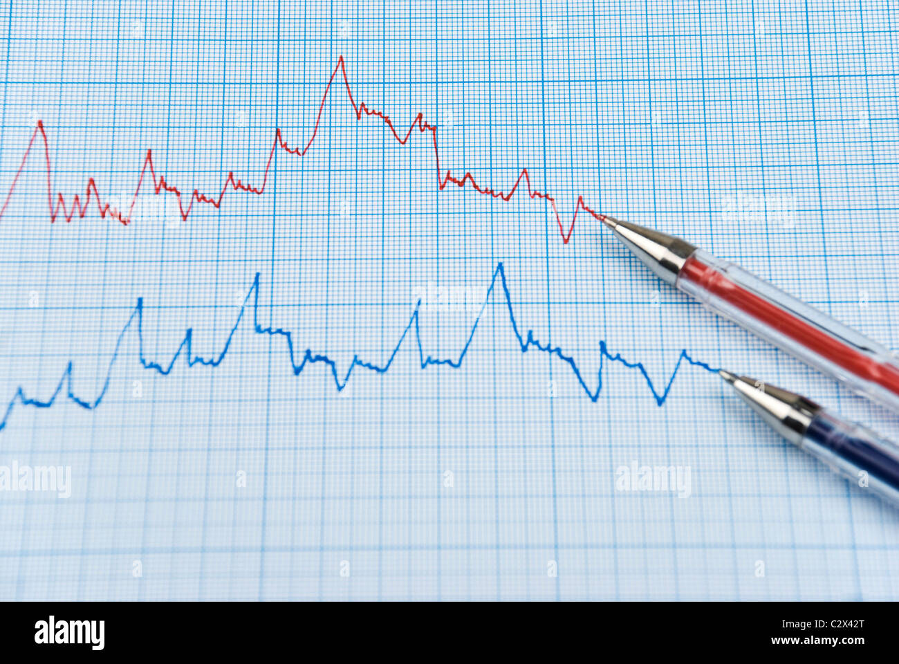 Financial chart shows a graph in two colors red and blue with two pens ...