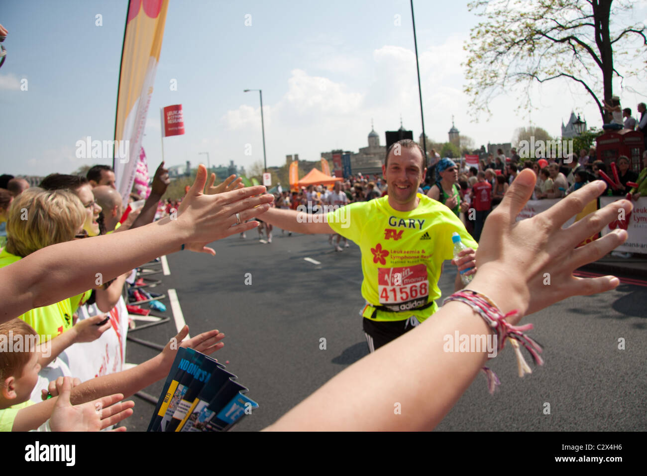 A charity runner in the 2011 London Marathon, and his supporters Stock ...