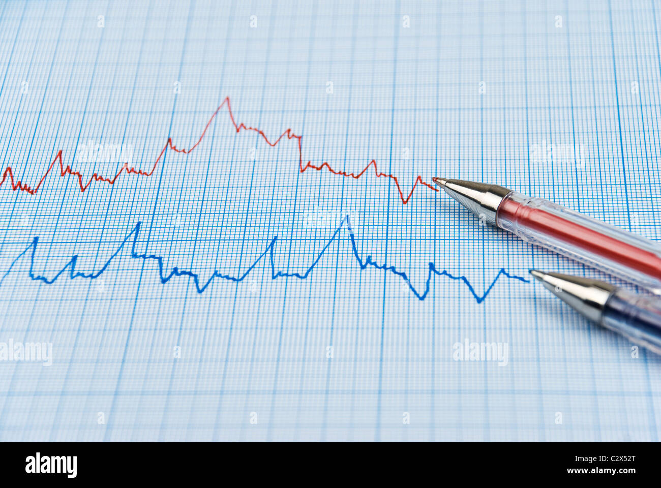 Financial chart shows a graph in two colors red and blue with two pens ...