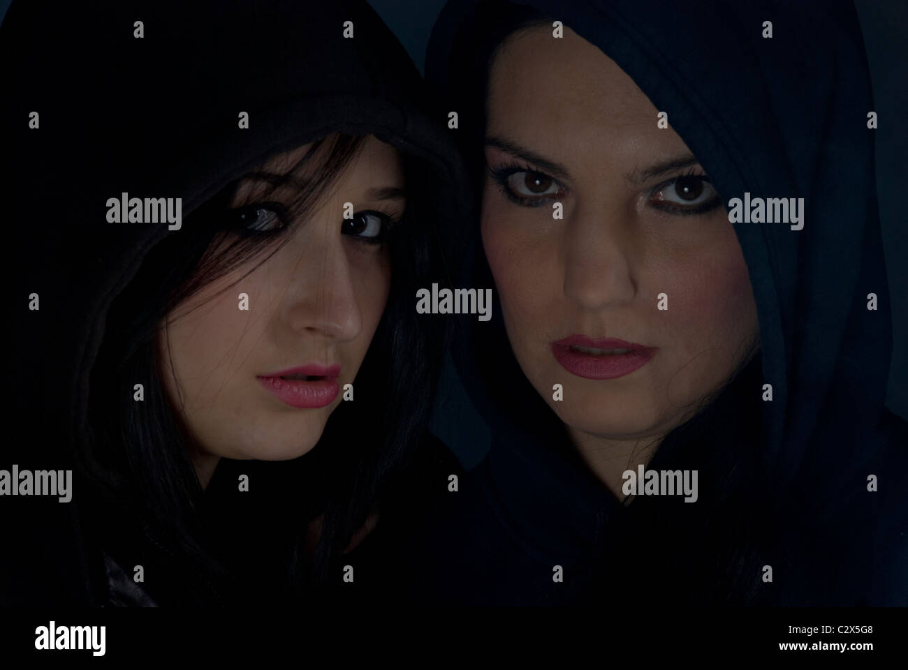 Bad girls wearing hood and looking you in darkness on street Stock ...