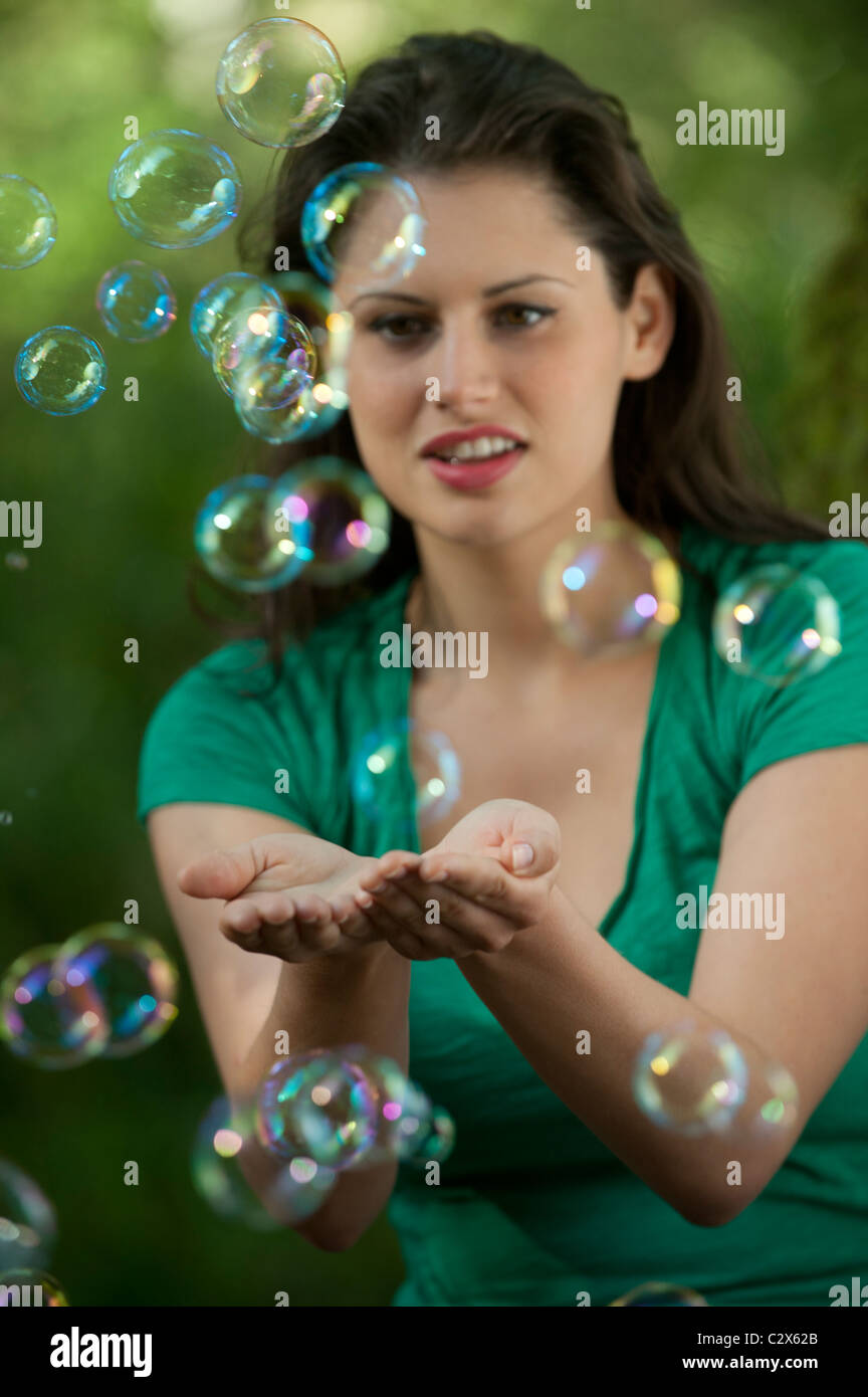 Caucasian woman trying to catch bubbles in her hands Stock Photo - Alamy