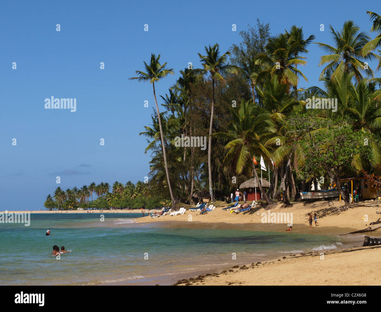 Las Terrenas beach on a sunny day with tourists and locals in the water ...