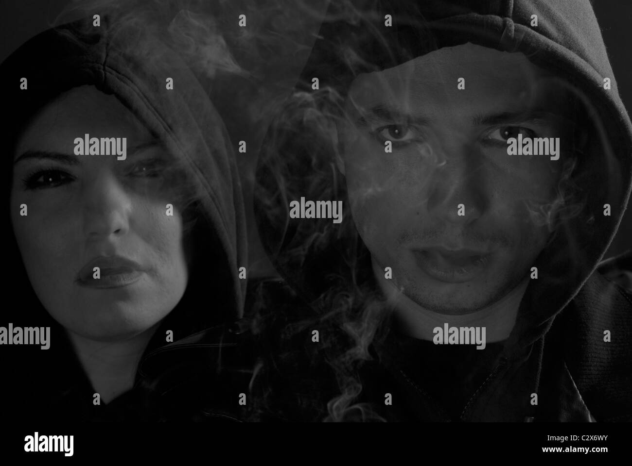 Hooded street people with smoke around them in night with white black ...