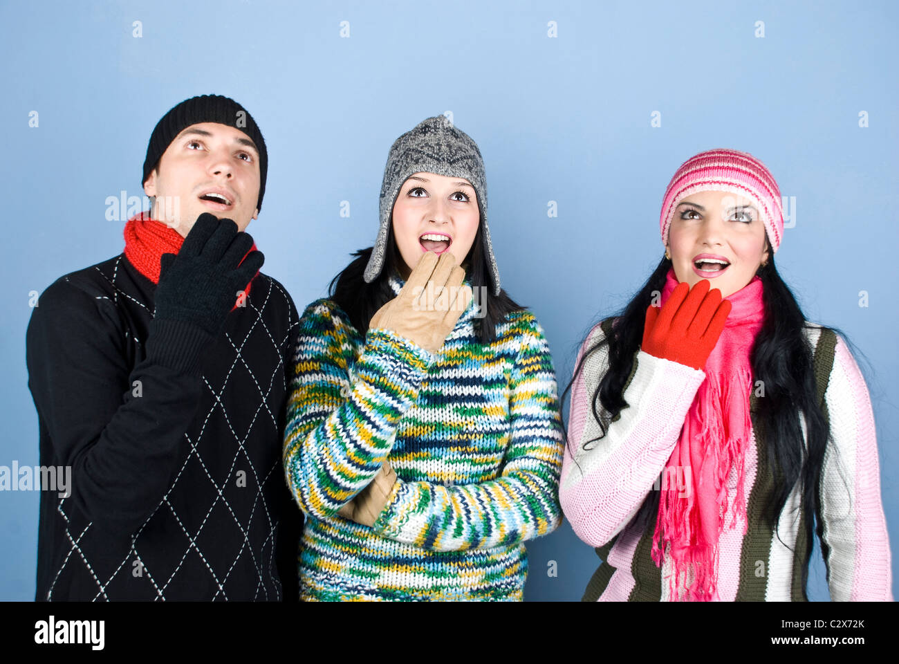 Surprised and happy people friends looking up at copy space and having ...