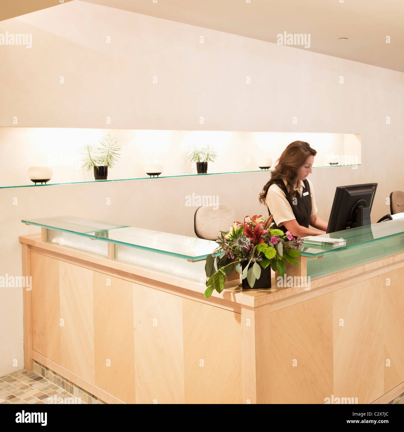 Woman working at spa resort desk Stock Photo - Alamy