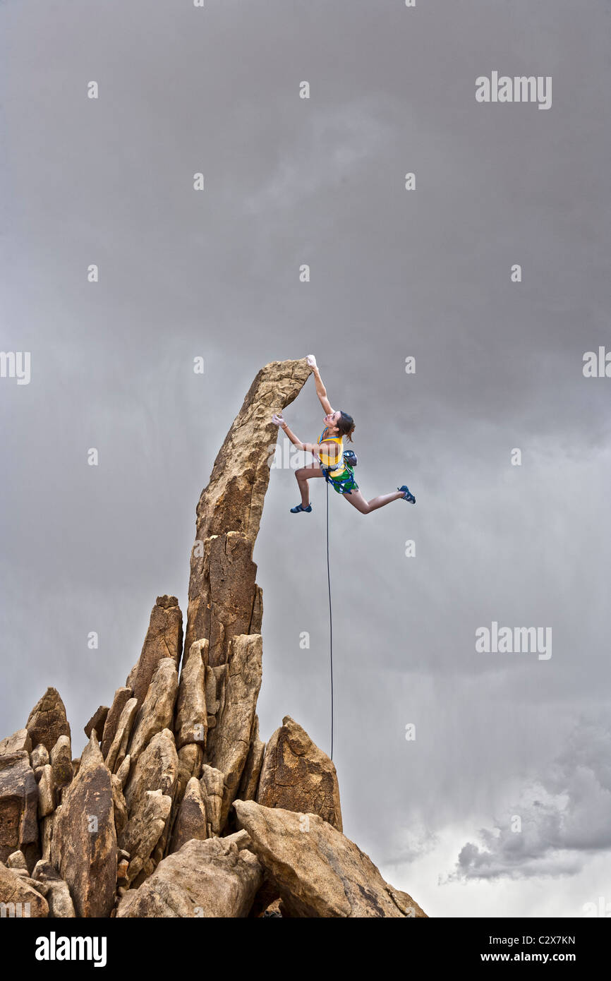 Female rock climbing dangling from the summit Stock Photo - Alamy