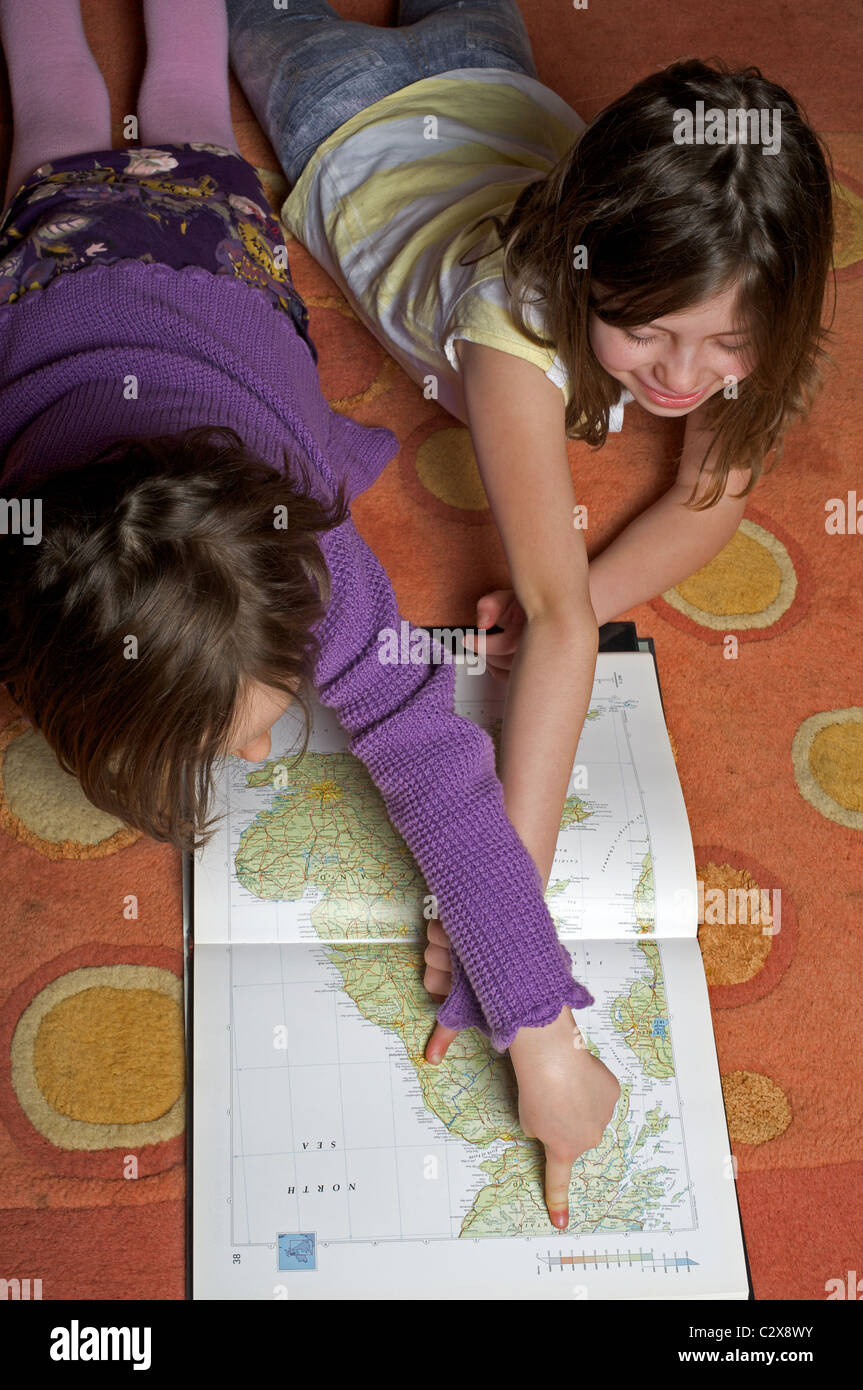 Two young girls looking at a map of the UK Stock Photo - Alamy