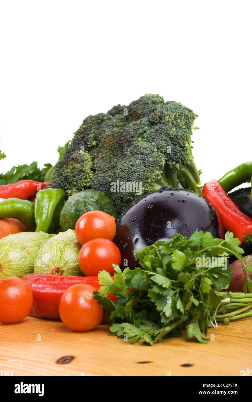Parsley and many fresh vegetables on a wood table isolated on white ...