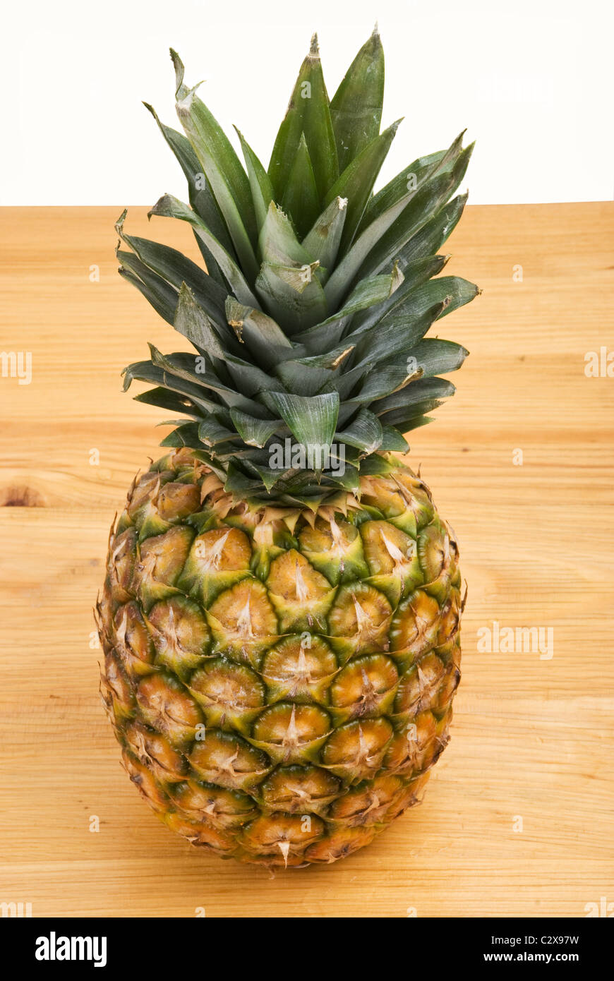 Whole pineapple fruit on a wood table and white background Stock Photo ...