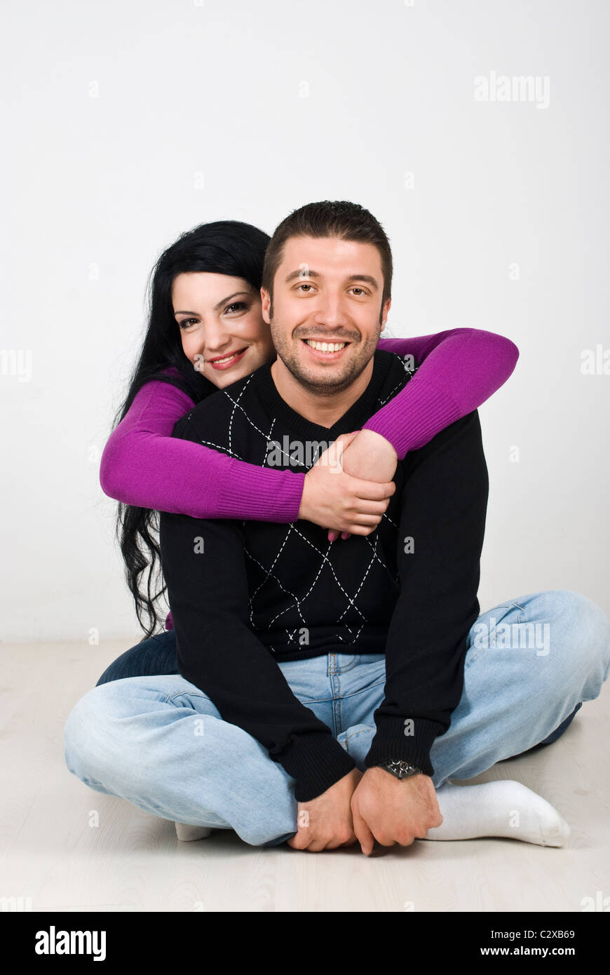 Happy young couple sitting on wooden floor loving,woman hugging her ...