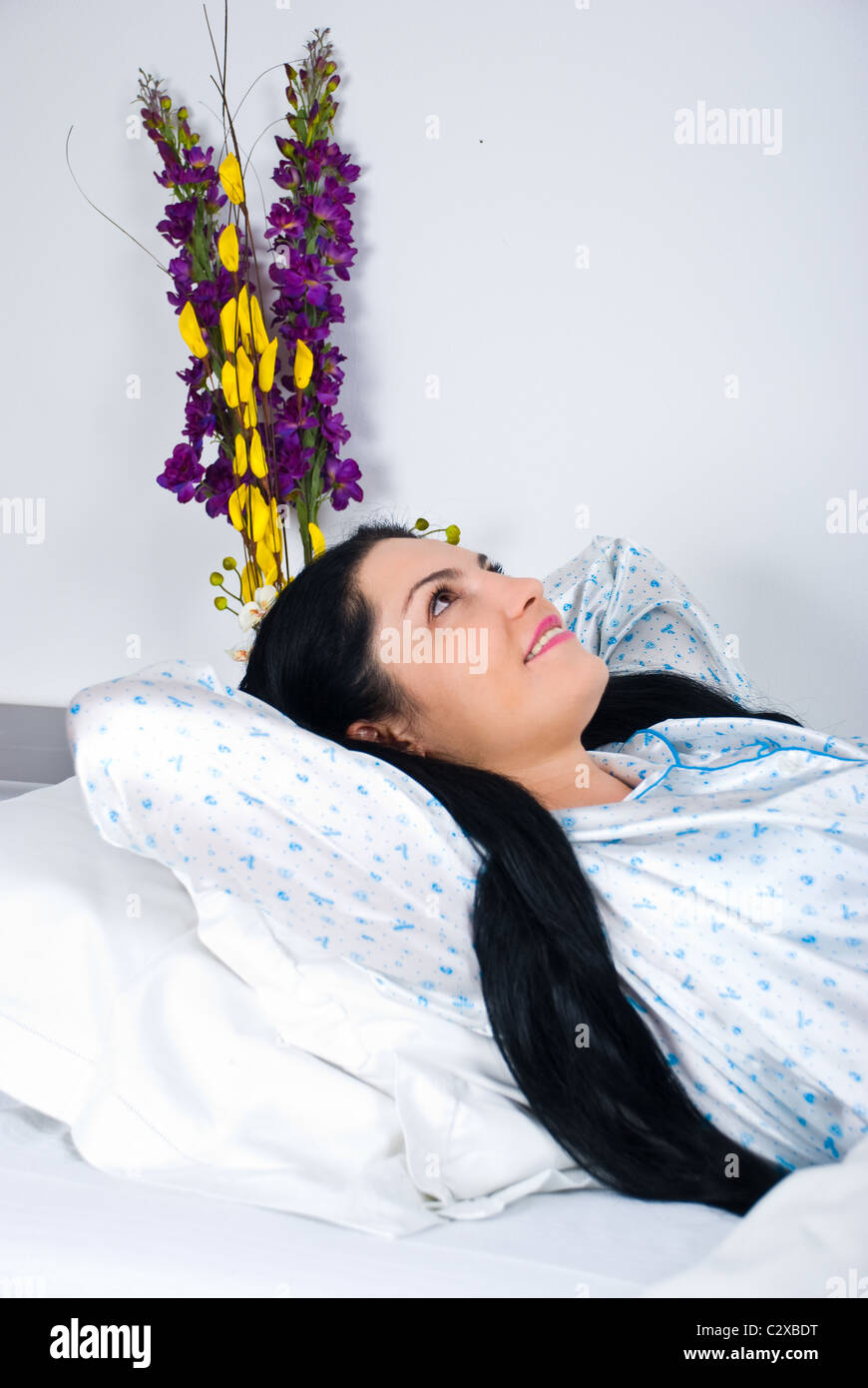Smiling woman relax in bed with hands under head looking up Stock Photo ...