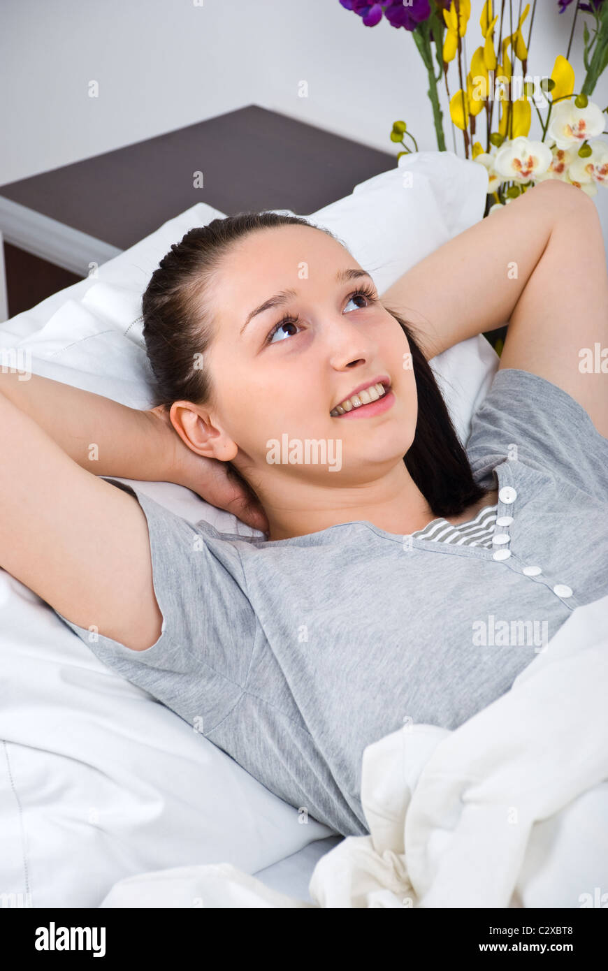 Thinking young woman lying in bed and relaxing Stock Photo - Alamy