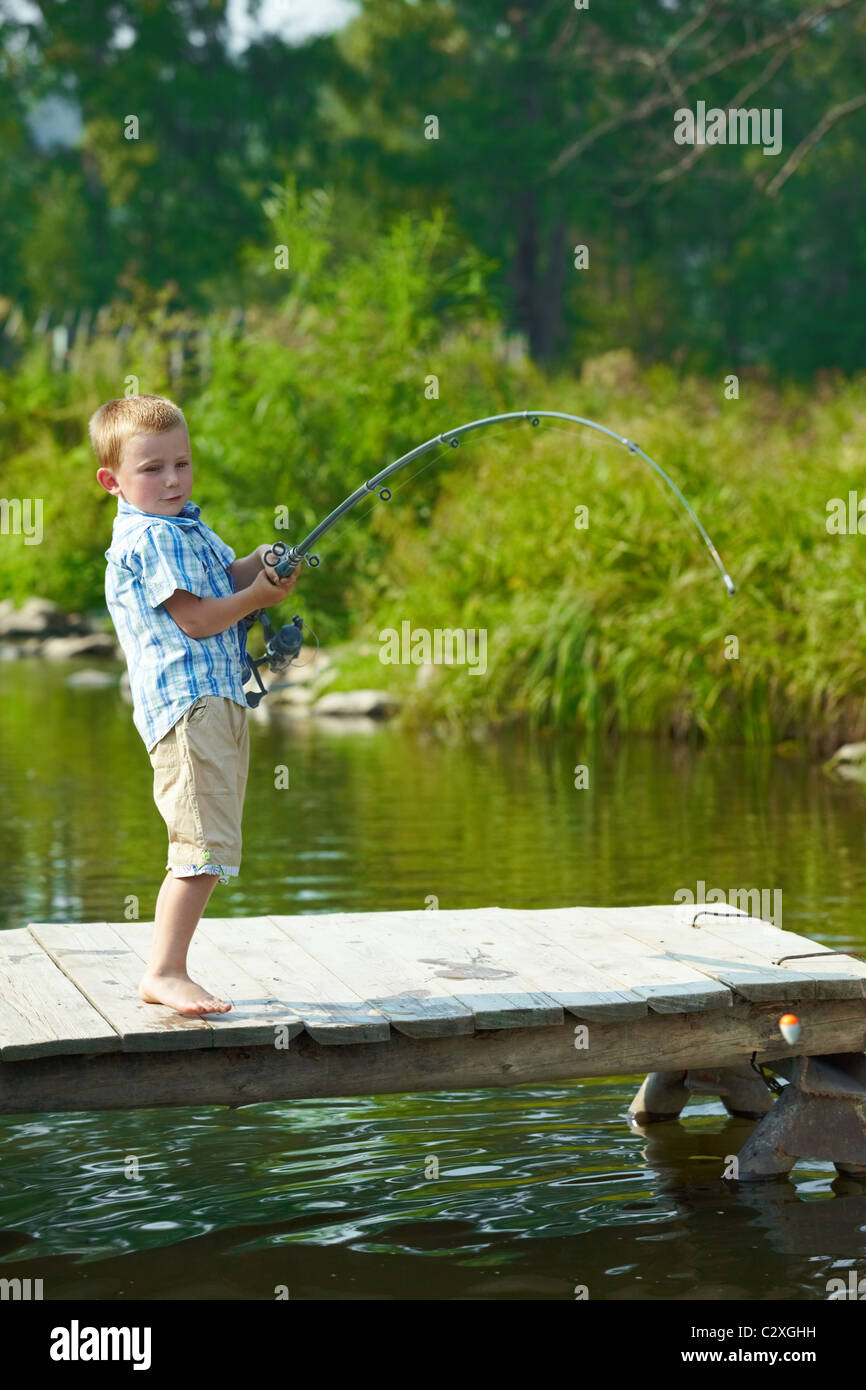 Photo of little kid pulling rod while fishing on weekend Stock Photo ...