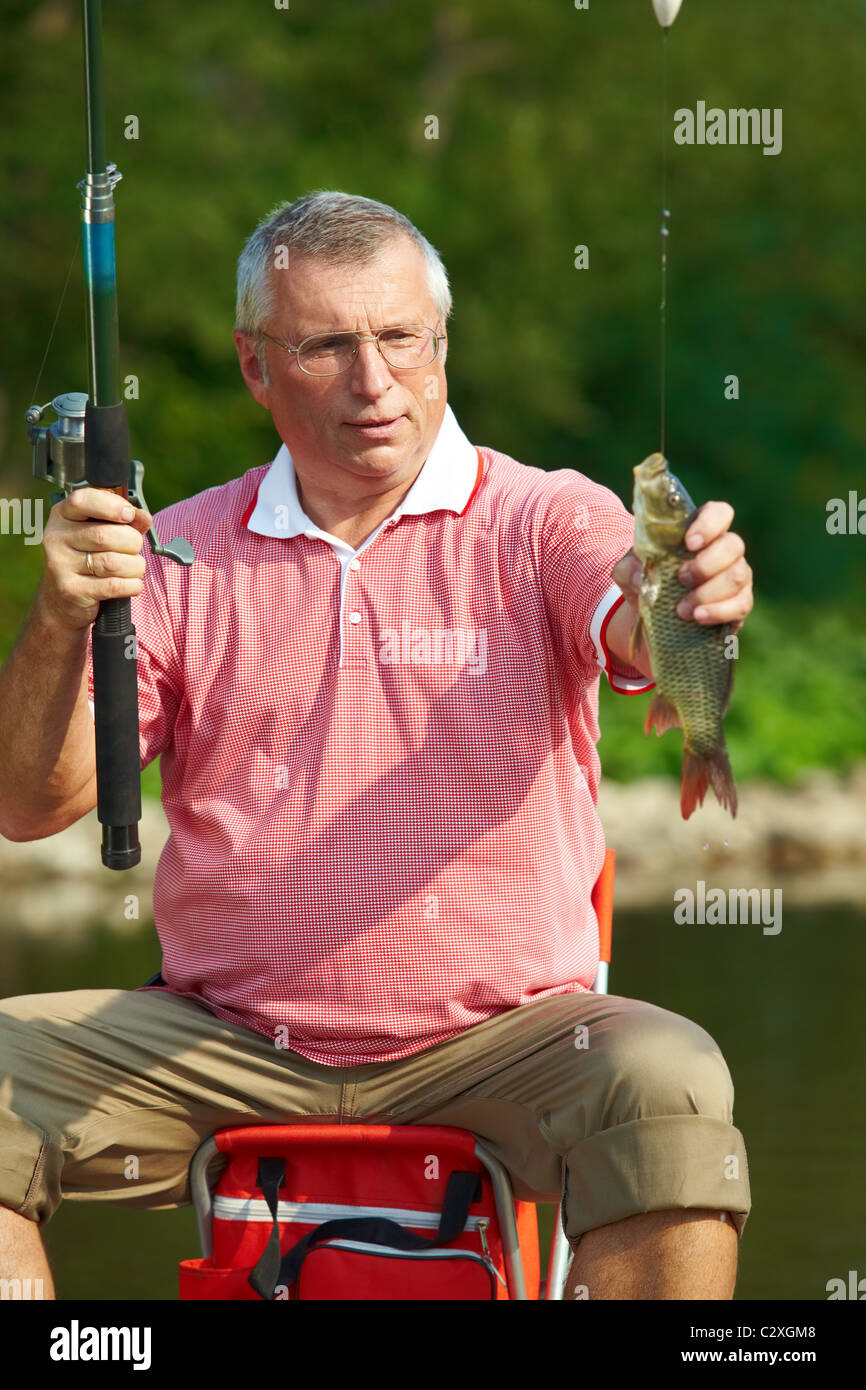 Senior fisherman holding fishing tackle hi-res stock photography and ...