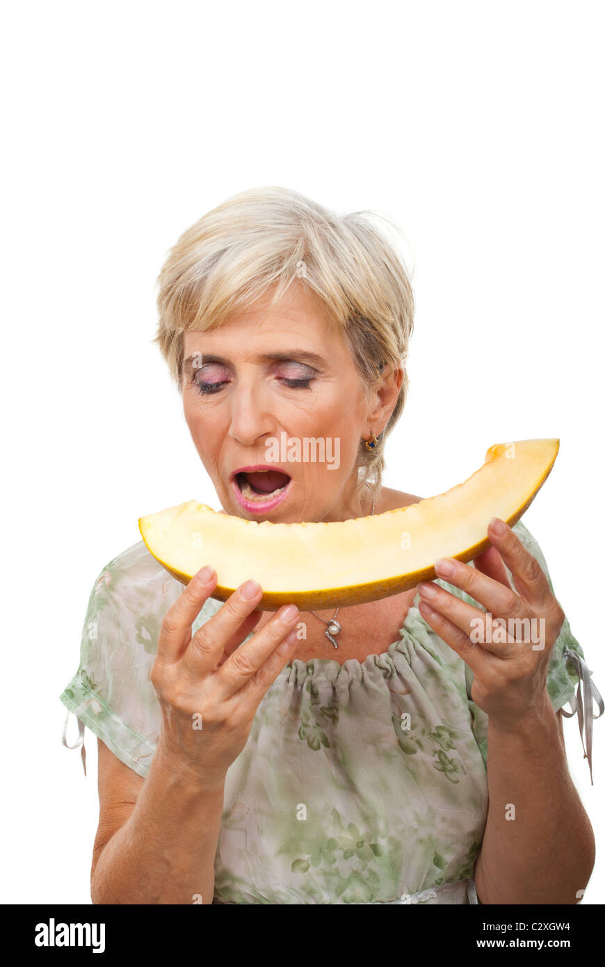Senior female preparing to bite a slice of melon isolated on white ...