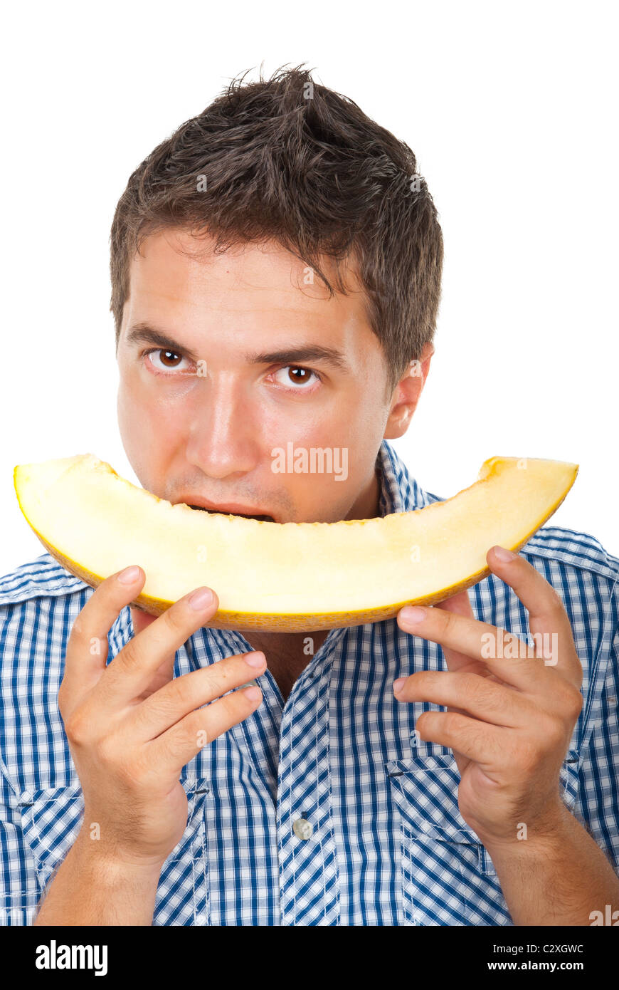 Young man eating a slice of cantaloupe isolated on white background ...