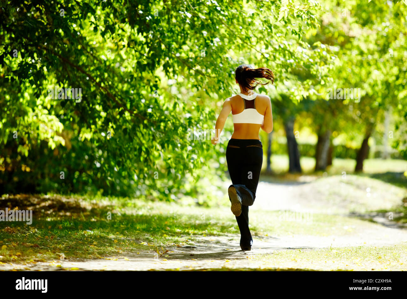 A young girl jogging in the park Stock Photo - Alamy