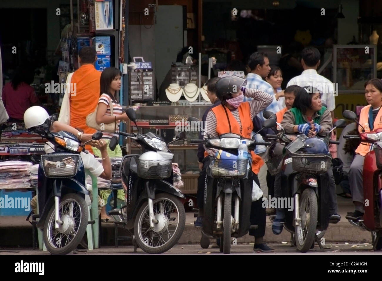 A group of motorcycle taxi drivers are waiting for passengers on a city ...